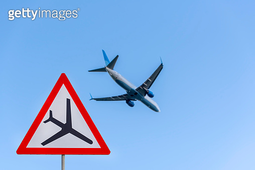 Airplane during take off and road airplane traffic sign, attention sign ...