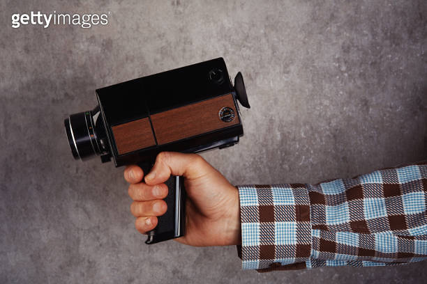 Camera operator holding an old fashioned analog Super8, 8mm film movie ...