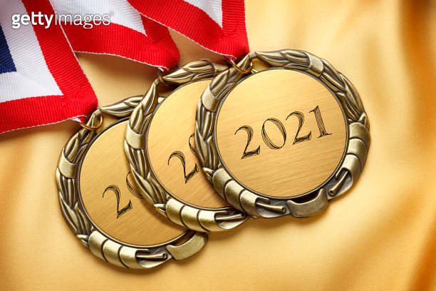2021 Engraved On Stack Of Gold Medals Resting On Gold Satin Fabric ...