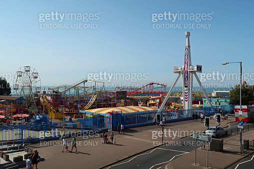 Seashore promenade and fun fair with sea / River Thames estuary in the ...