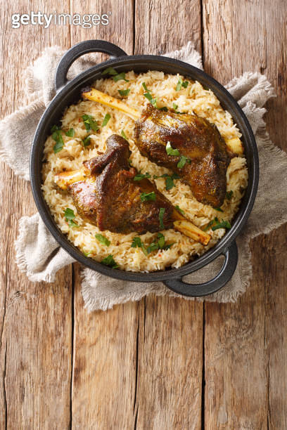 Yemeni dish of baked lamb shank served with aromatic rice close-up in a ...