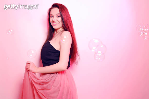 Beauty brunette girl with long hair. Model in a pink dress, flying ...