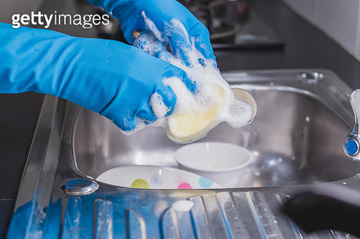 Washing a spoon with a dish washing liquid. (1198144937) - 게티이미지뱅크