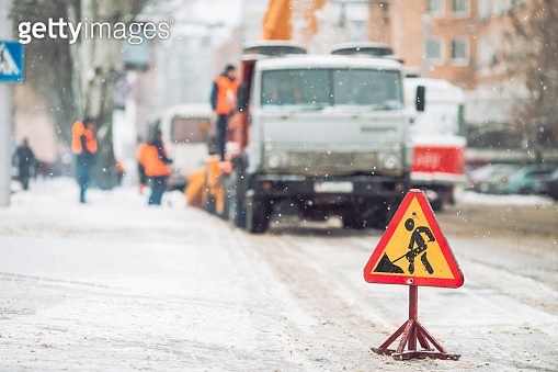Snow-plow remove snow from the city street.Warning road sign.Winter ...