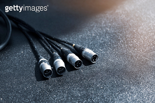In preparation for a concert, the audio cables stand on a black podium ...