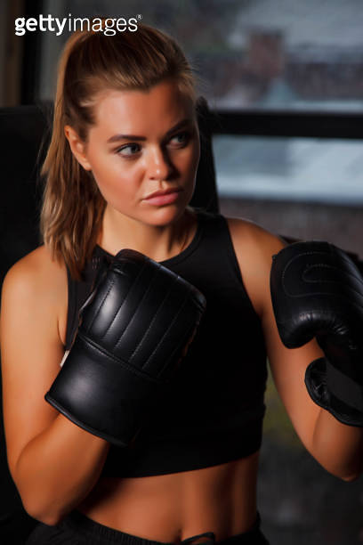Pretty young female boxer stand in corner Boxing ring holding up hands ...