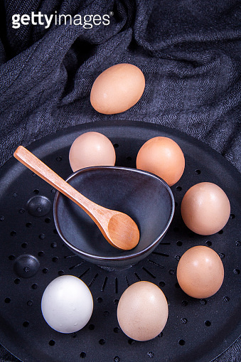 Some native eggs are in a wooden basket on a white cloth. (1263196466 ...