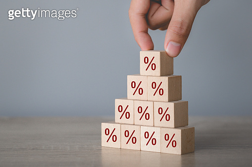 Hand arranging wood block stacking with icon percent symbol upward ...