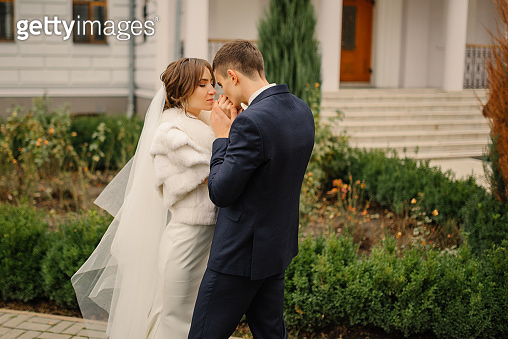 Bride and groom couple in love at wedding day, groom kisses the hands ...