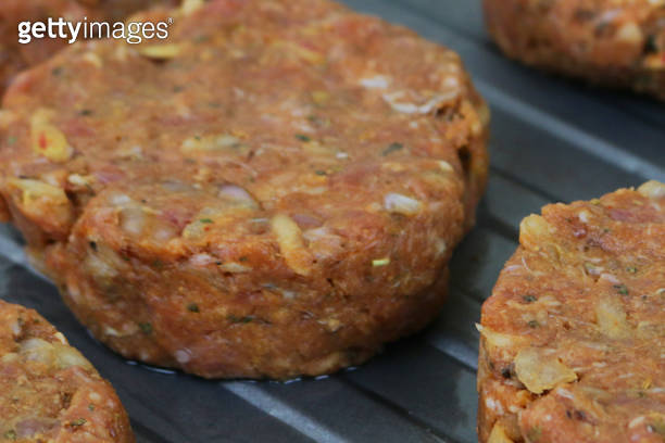 Close-up image of rows of homemade beef burger patties, baking tray on ...