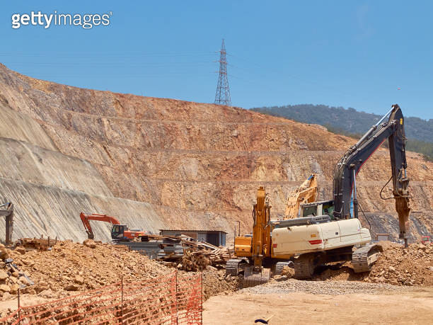 Excavator and hydrohammer during quarrying on the rocky soils. Heavy ...