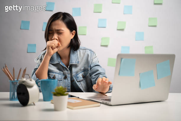 Asian woman working on a laptop was sick with fever sitting at home ...