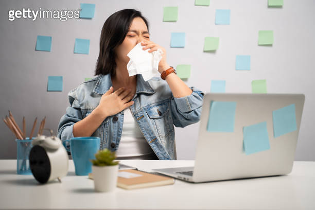 Asian woman working on a laptop was sick with fever sitting at home ...