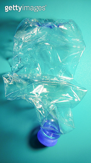Compressed water bottle on blue background. Empty, squashed water ...