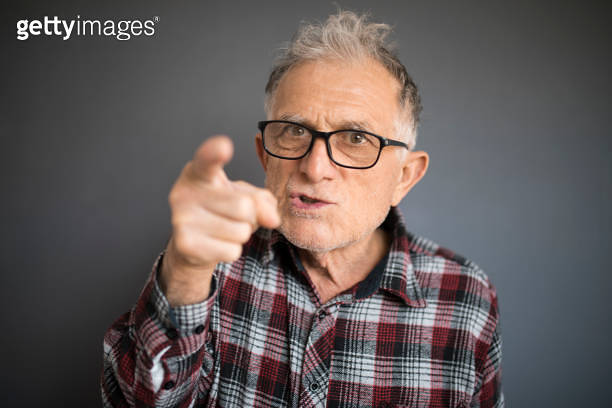 Serious senior man with funny messy hair wagging his finger at the ...