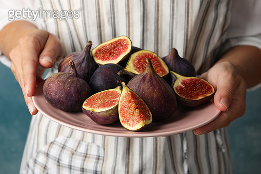 Woman hold plate with fig, front view (1267327094) - 게티이미지뱅크