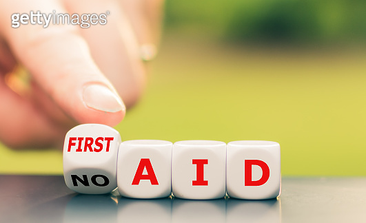 Hand turns a dice and changes the expression "no aid" to "first aid ...