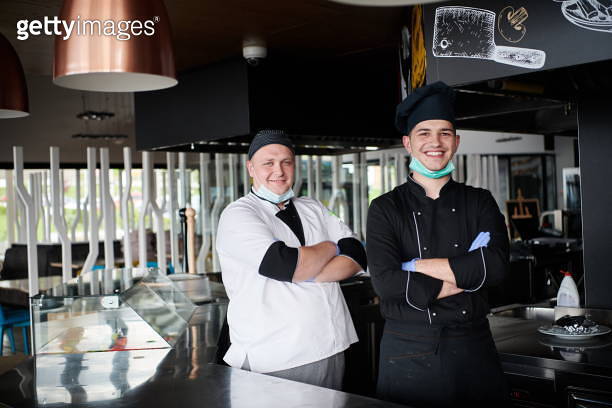 group chefs standing together in the kitchen at restaurant wearing ...