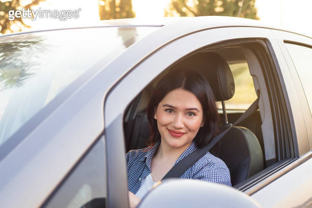 Happy woman driving a car and smiling. Cute young success happy woman ...