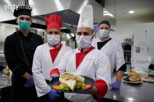 group chefs standing together in the kitchen at restaurant wearing ...