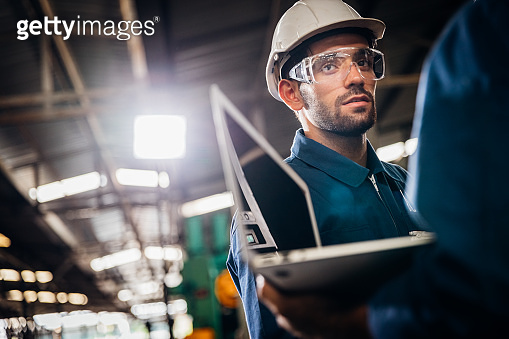 Industry maintenance engineer wearing uniform and safety helmet under ...