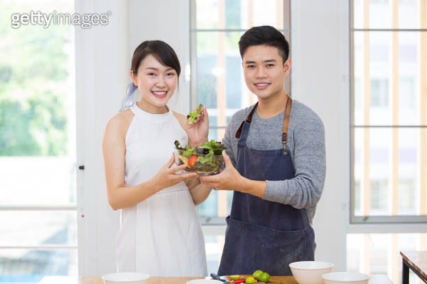 Asian couples making salads and eating cleanfood , healthy meals. Stay ...