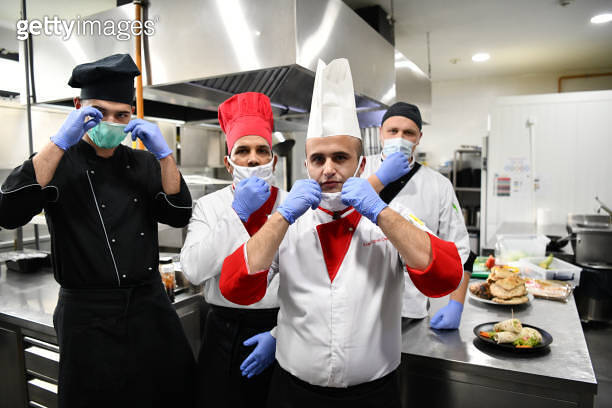 group chefs standing together in the kitchen at restaurant wearing ...