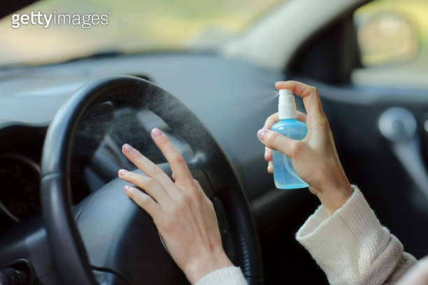 Hand of woman is spraying alcohol,disinfectant spray in car,safety ...