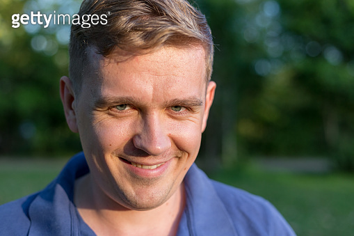 Portrait of a young man on nature background. Emotion facial expression ...
