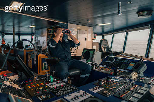 Navigational officer lookout on navigation watch looking through ...