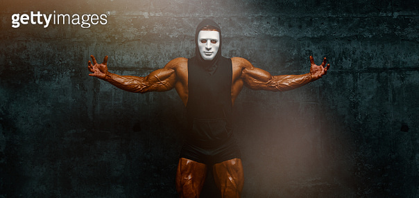Mysterious Muscular man hiding behind mask Flexing Muscles. Bodybuilder ...