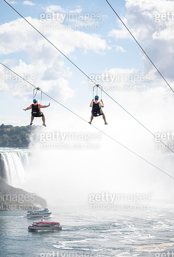 People riding on the WildPlay Niagara Falls MistRider Zipline on a ...