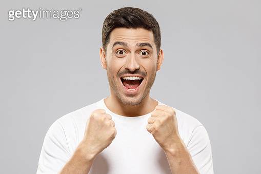 Young handsome guy shouting and clenching fists because he has win ...