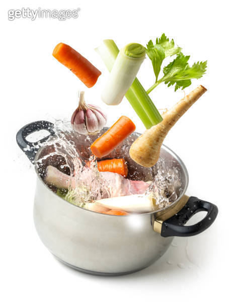 boiling vegetables flying towards the pot, on white isolated background ...