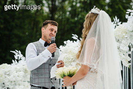 Happy bride and groom exchanging wedding vows on ceremony under the ...