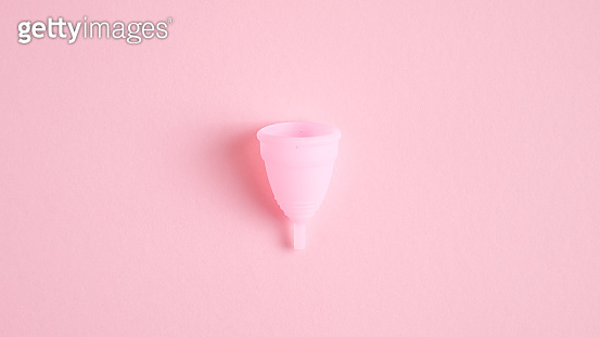Reusable menstrual cup isolated on pink background. Alternative ...
