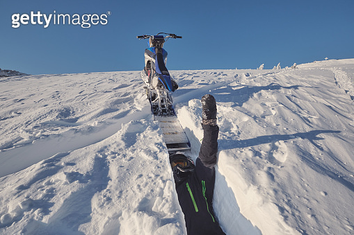 Snowbike rider in mountain valley. Modify dirt bike with snow splashes ...