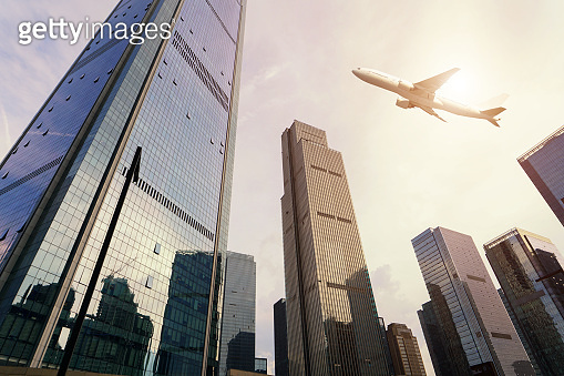 airplane fly over modern office buildings in downtown with sunshine ...