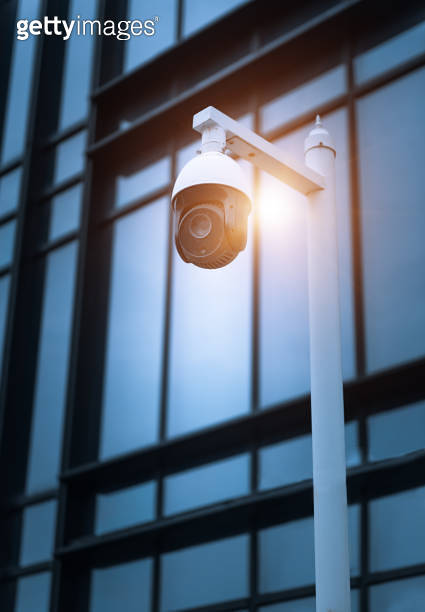 Security surveillance cameras in front of high-rise business district ...