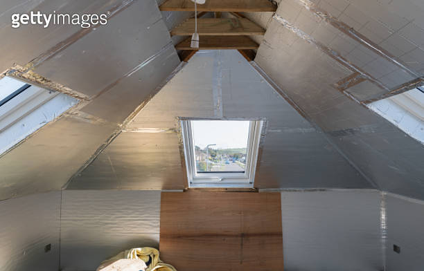 Unfinished residential loft conversion with silver insulation ...