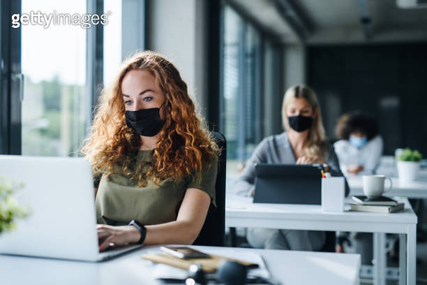 Young people with face masks back at work or school in office after ...