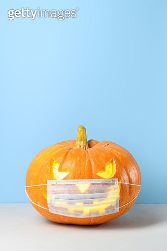 New normal concept. Glowing Halloween pumpkin in a protective medical ...