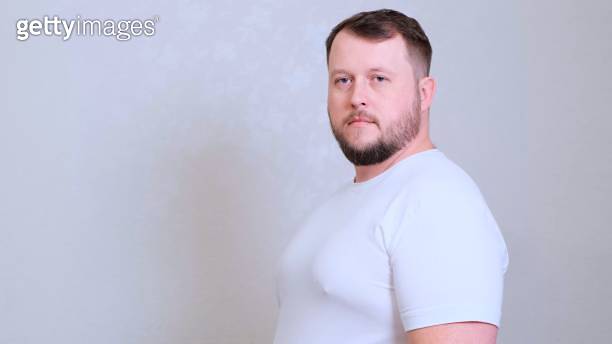 Closeup portrait of a Caucasian big fat man with green eyes looking ...