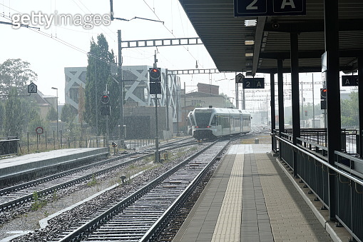 An electric motor-coach train approaching railway platform in the ...