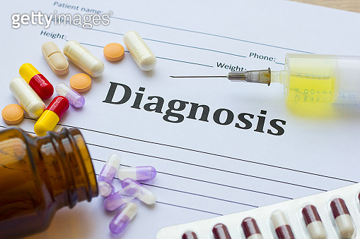 Diagnosis on white paper with medication injection, syringe and pills ...