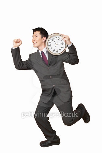 Side profile of a businessman carrying a wall clock and running ...