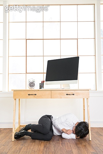 A man under the desk 이미지 (a10685021) - 게티이미지뱅크