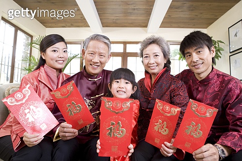 Three generation family holding Chinese new year red envelope ...