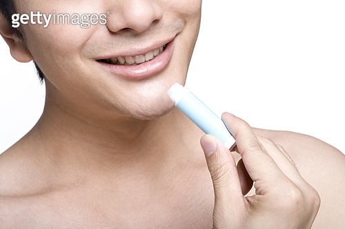 Young man using lip balm 이미지 (a10728983) - 게티이미지뱅크