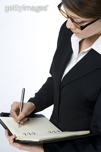 Young businesswoman busy in taking notes 이미지 (a10731596) - 게티이미지뱅크
